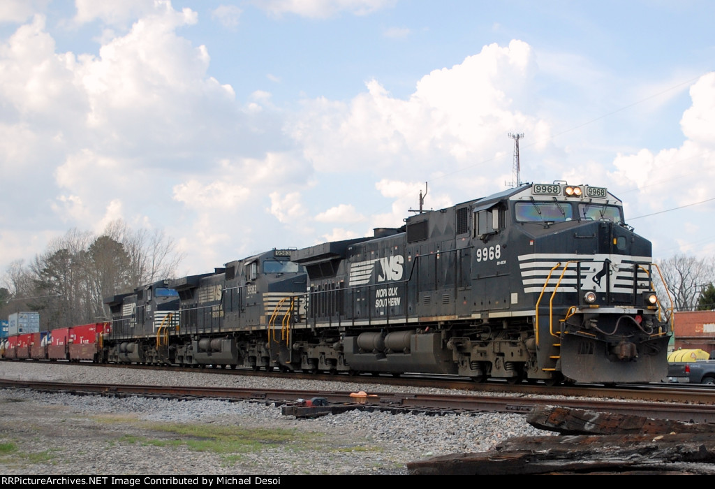 NS C40-9W #9968 leads an eastbound stack train across Main St.